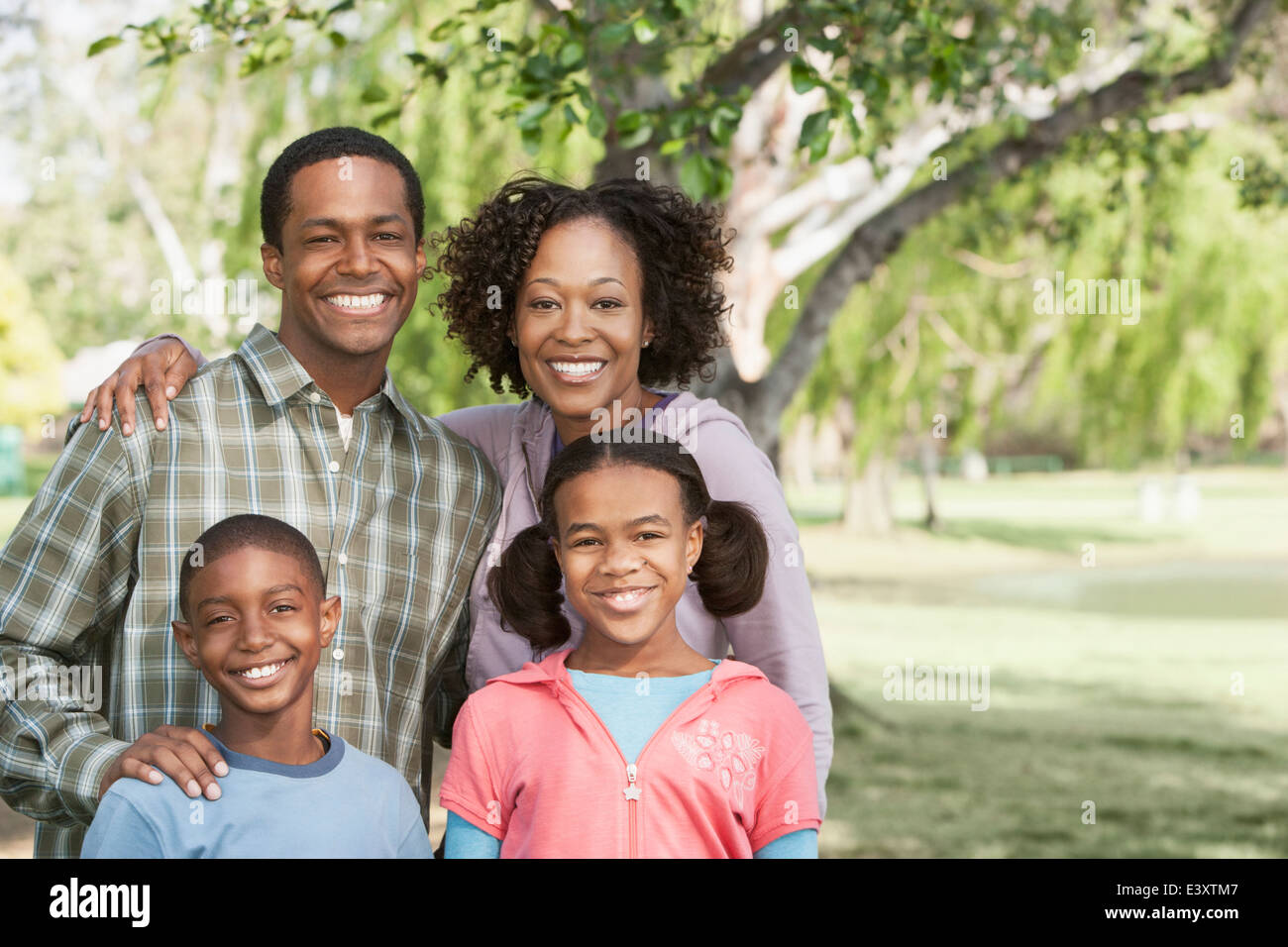 Family smiling together in park Stock Photo - Alamy