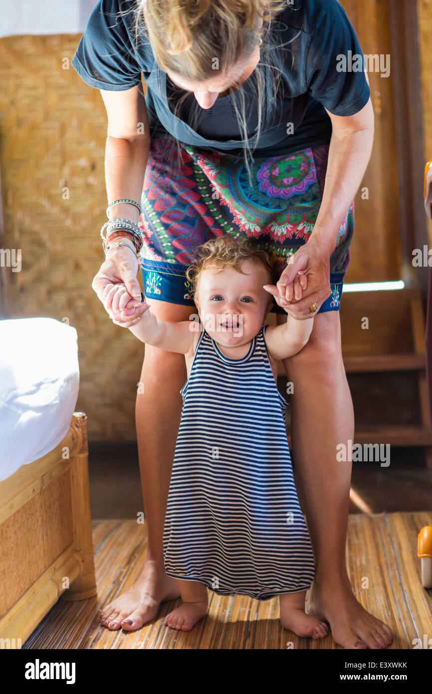 Caucasian mother helping baby stand Stock Photo - Alamy