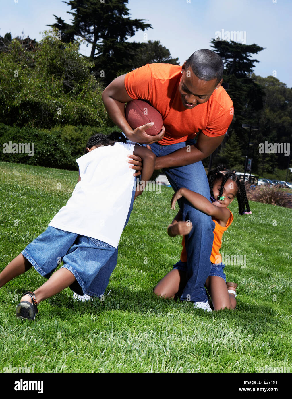 Father and children playing in park Stock Photo - Alamy