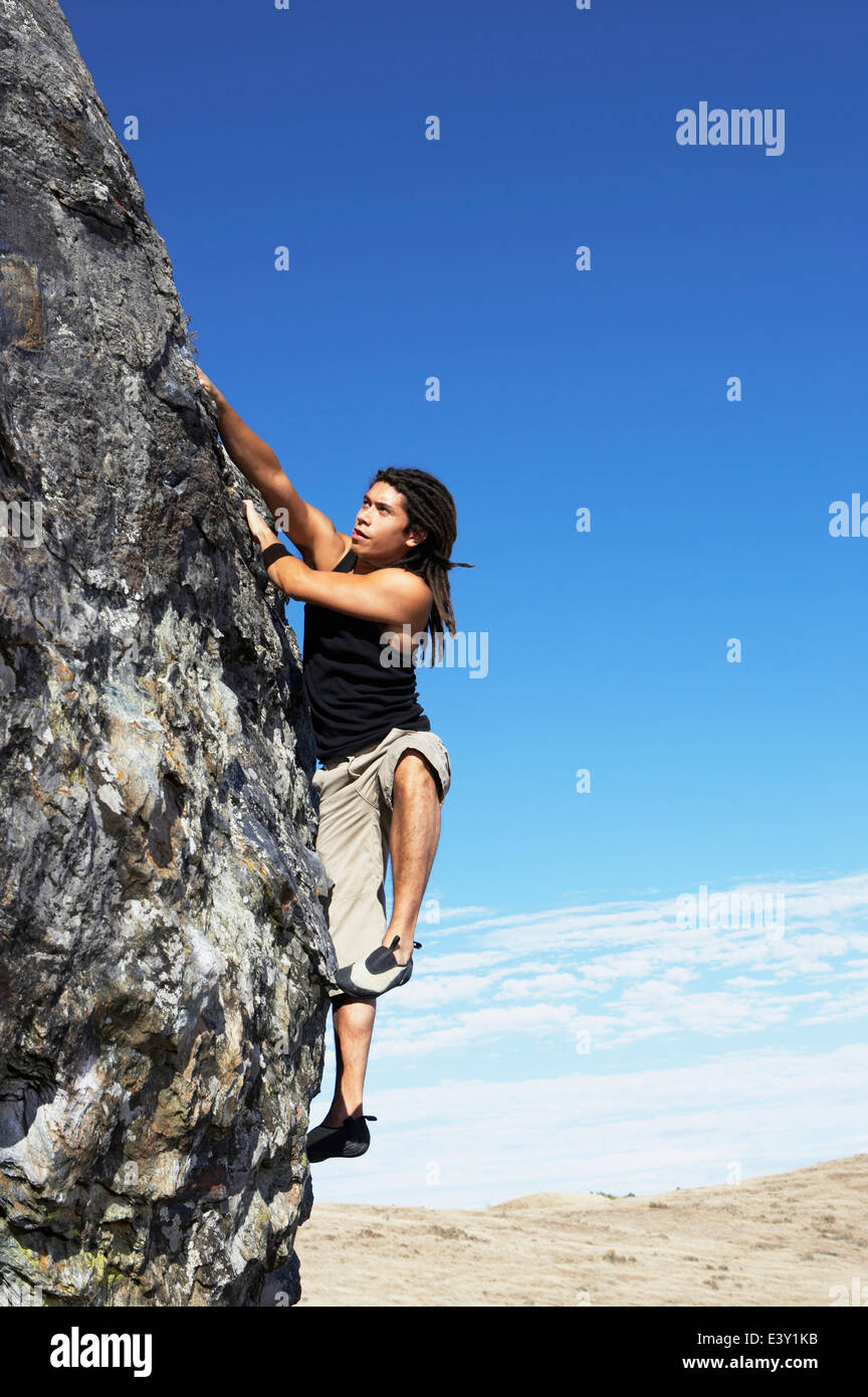 Hispanic climber scaling steep rock face Stock Photo - Alamy