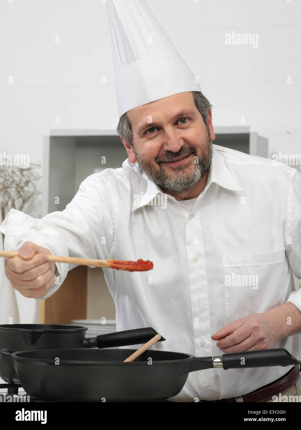 Chef offering taste of food in kitchen Stock Photo - Alamy