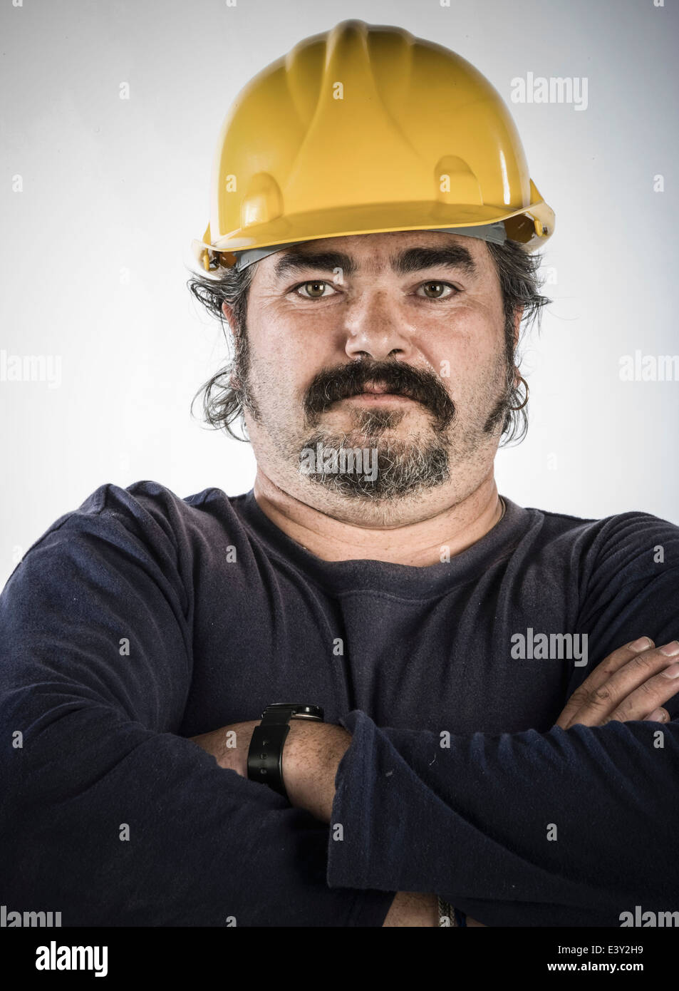 Construction worker standing with arms crossed Stock Photo - Alamy