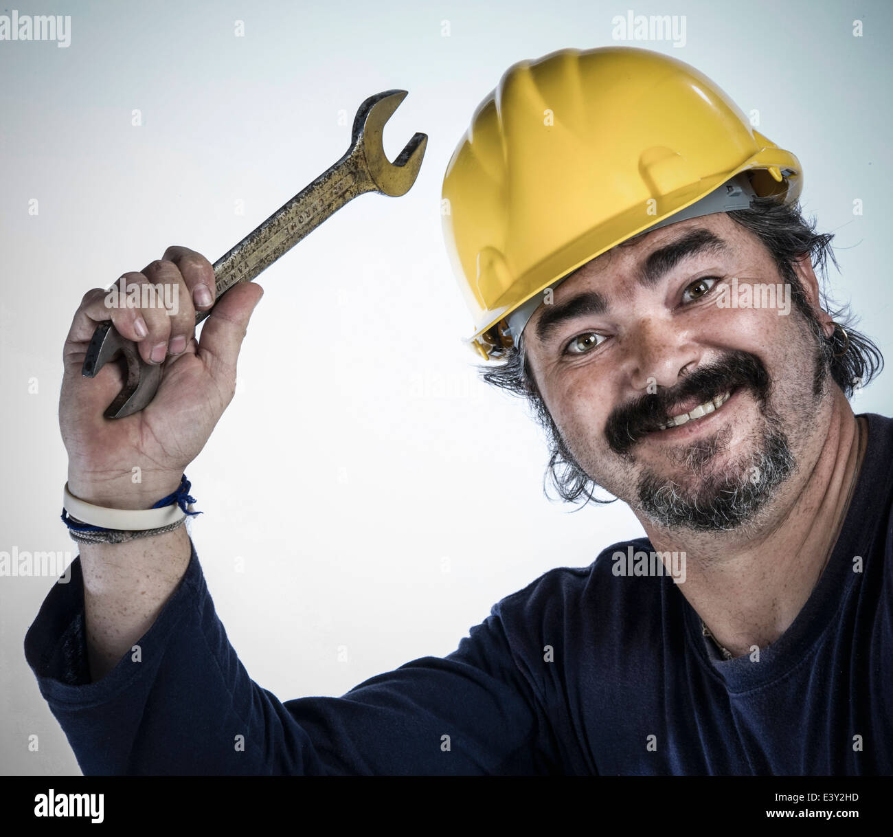 Construction worker holding wrench Stock Photo - Alamy