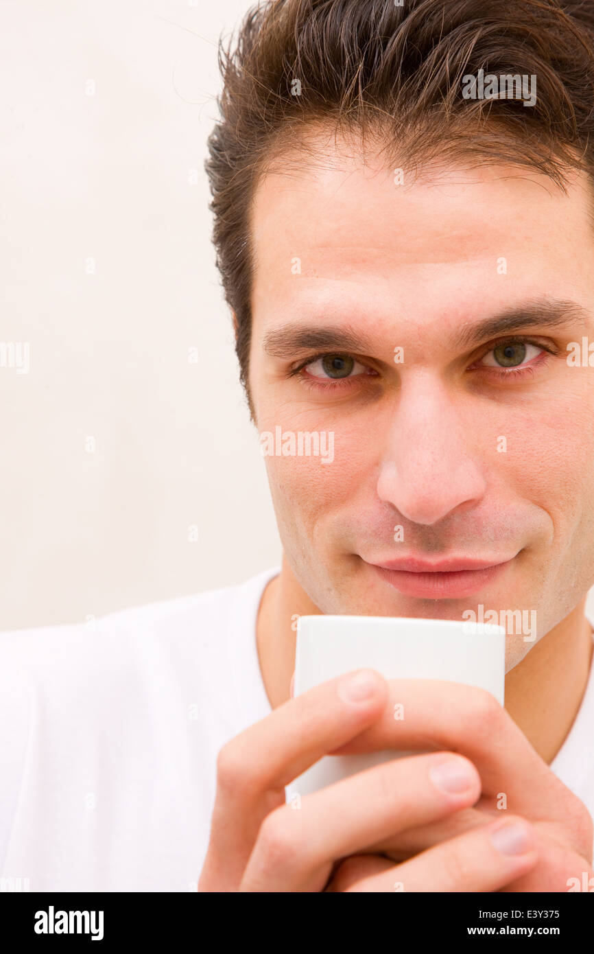Smiling young man holding cup Stock Photo - Alamy
