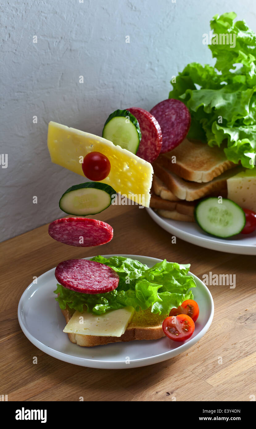 magic sandwich with salami and cheese on wooden table Stock Photo - Alamy