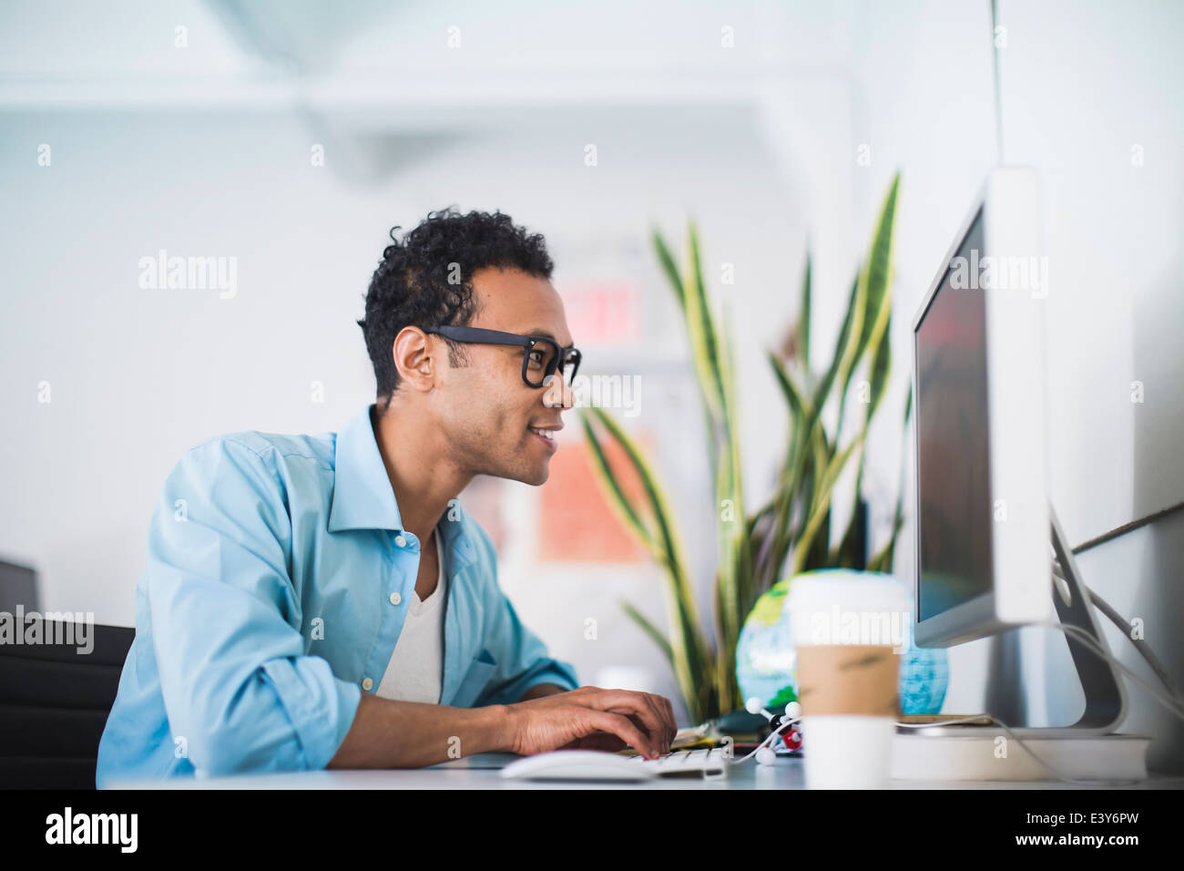 Young man working at computer in office Stock Photo - Alamy