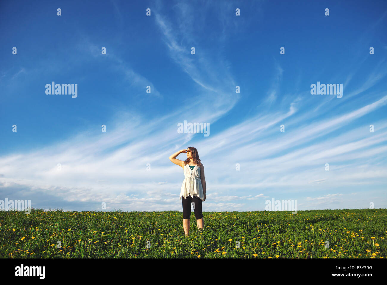 Young woman standing in field Stock Photo - Alamy