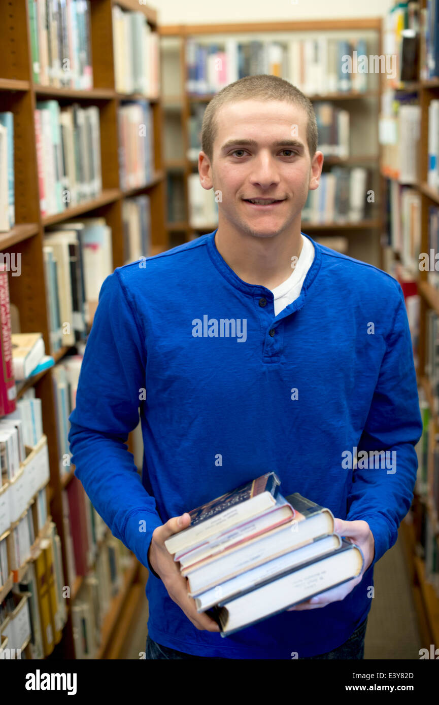 Young man holding books Stock Photo - Alamy