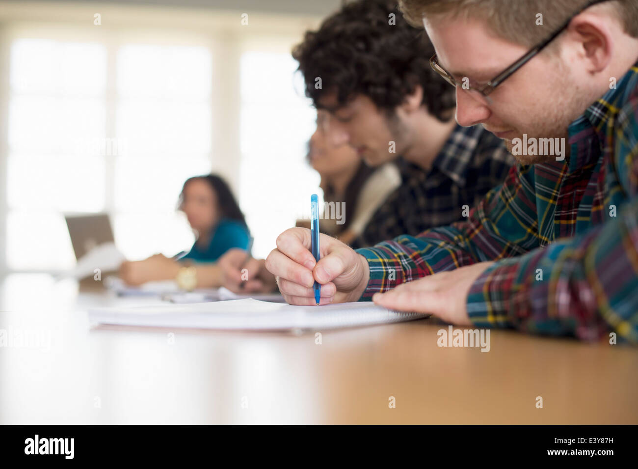 Students writing in classroom Stock Photo - Alamy