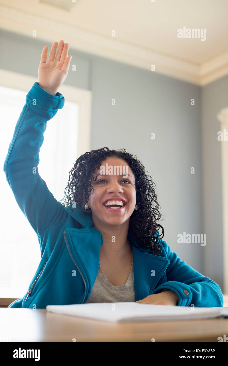 University student with raised hand Stock Photo - Alamy