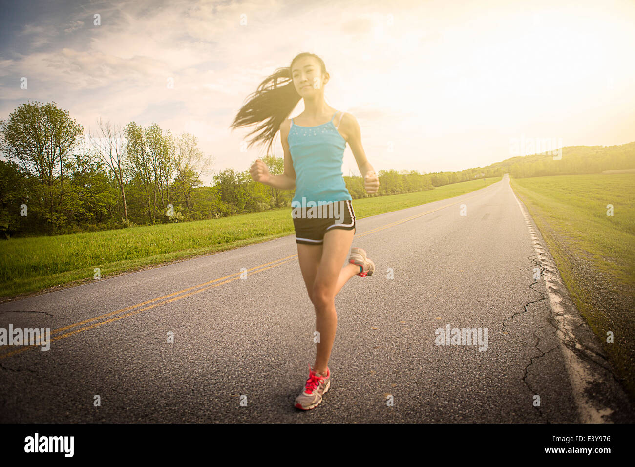 Teenage girl running on road Stock Photo - Alamy