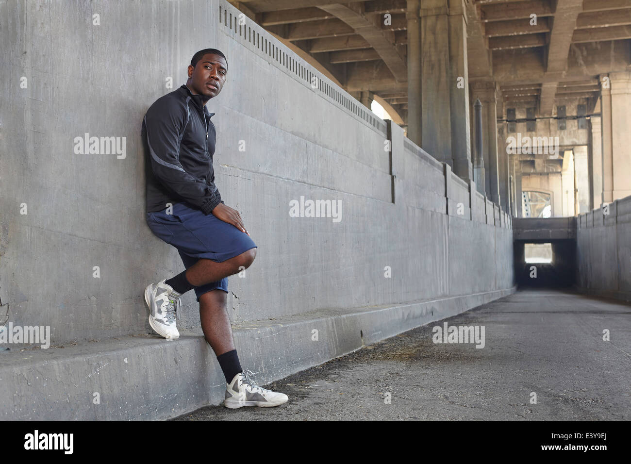 Young male runner taking a break on city bridge Stock Photo - Alamy