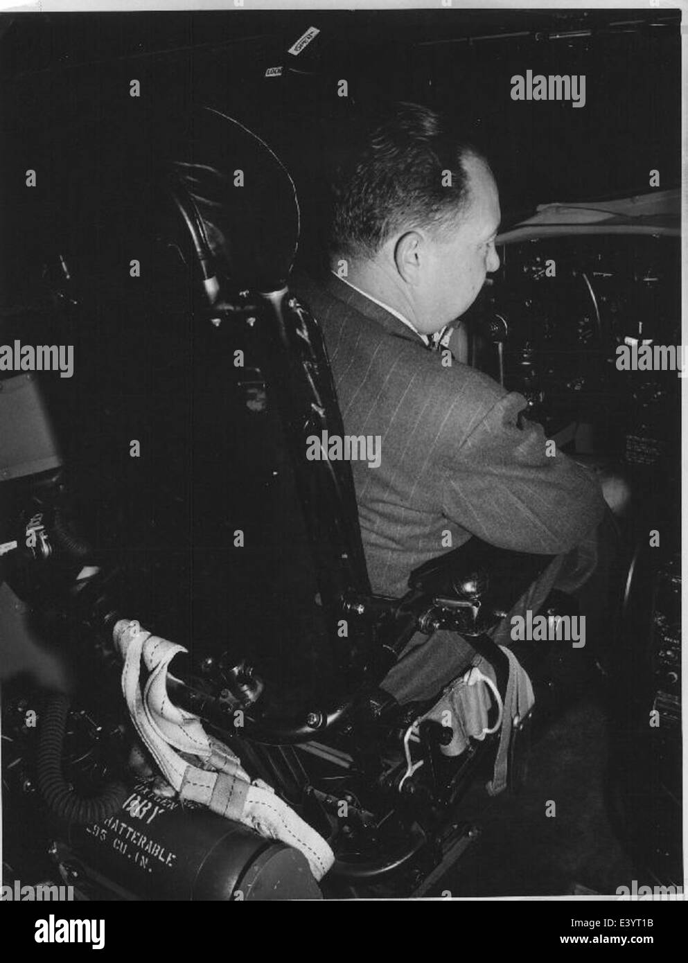 This photograph features Charles Babb sitting in the pilot's seat of an ...