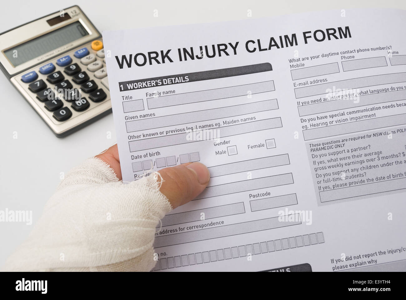 hurted hand holding a work injury claim form Stock Photo - Alamy