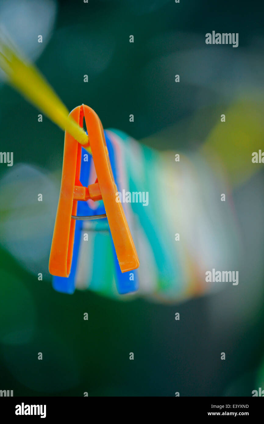 Colorful clothes pegs hanging in wire Stock Photo - Alamy