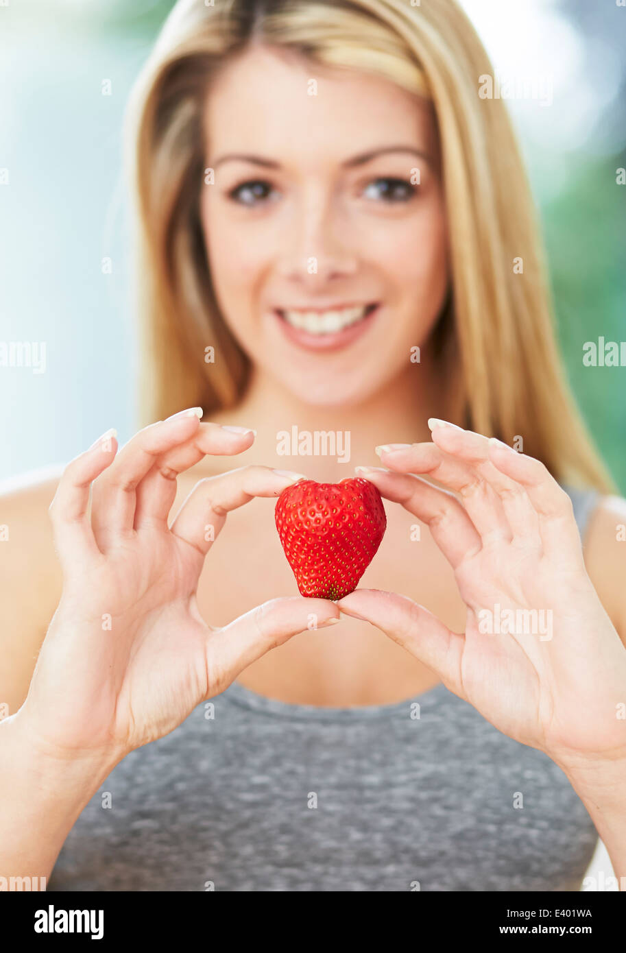 Woman eating a Strawberry Stock Photo - Alamy