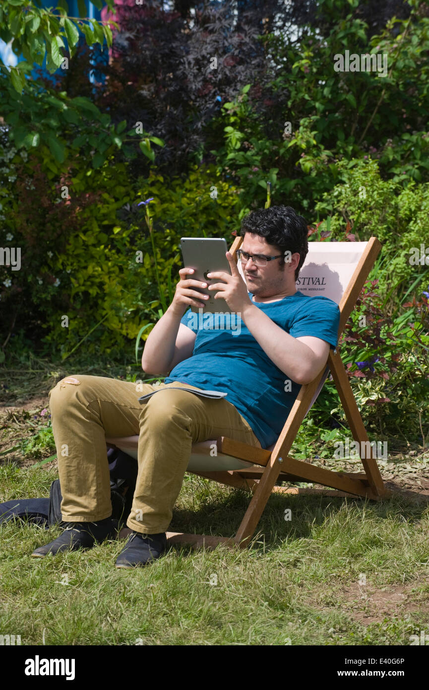 Man sitting in deckchair using ipad at Hay Festival 2014 ©Jeff Morgan ...
