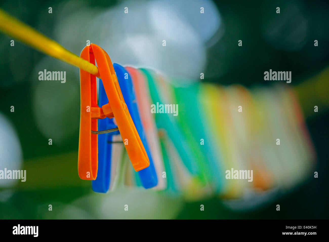 Colorful clothes pegs hanging in wire Stock Photo - Alamy