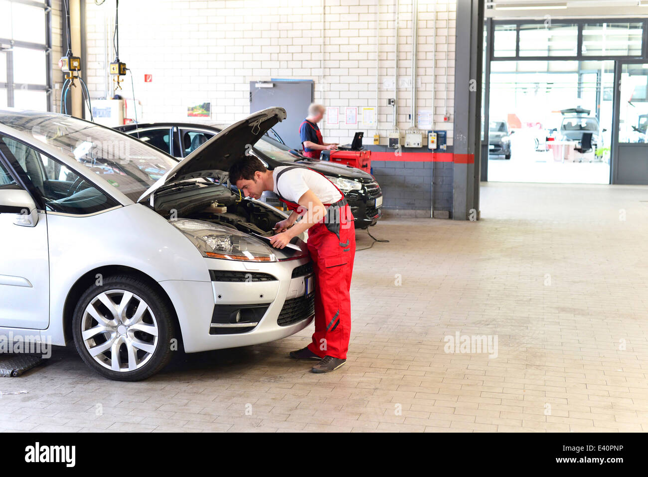 Car mechanic in a workshop working at car Stock Photo - Alamy
