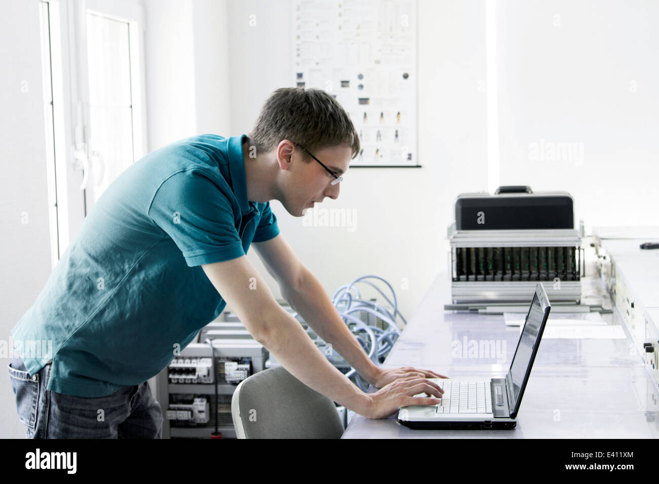 Electronic apprentice with laptop at workshop Stock Photo - Alamy