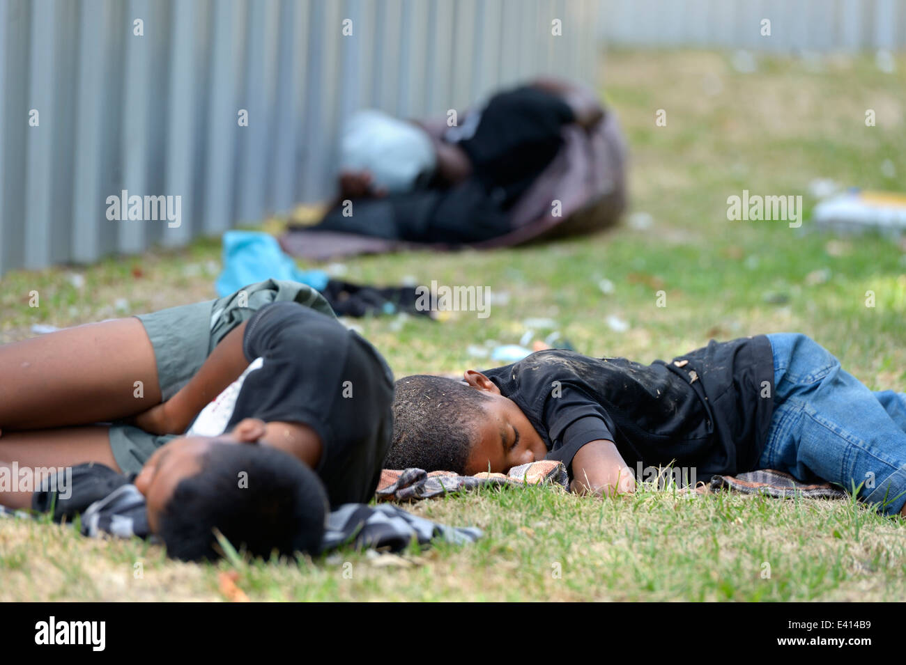 Brazil, Rio de Janeiro, two street children sleeping on meadow in front ...