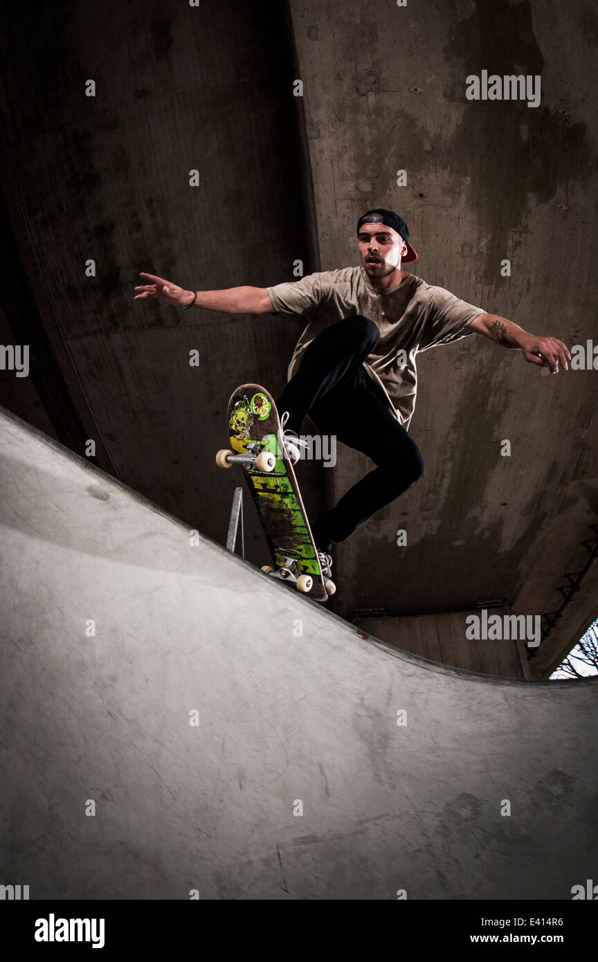 Skateboarder performing trick at skateboard park Stock Photo - Alamy
