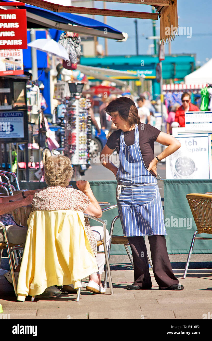 Waitress talking to customer sat at pavement cafe table Stock Photo - Alamy