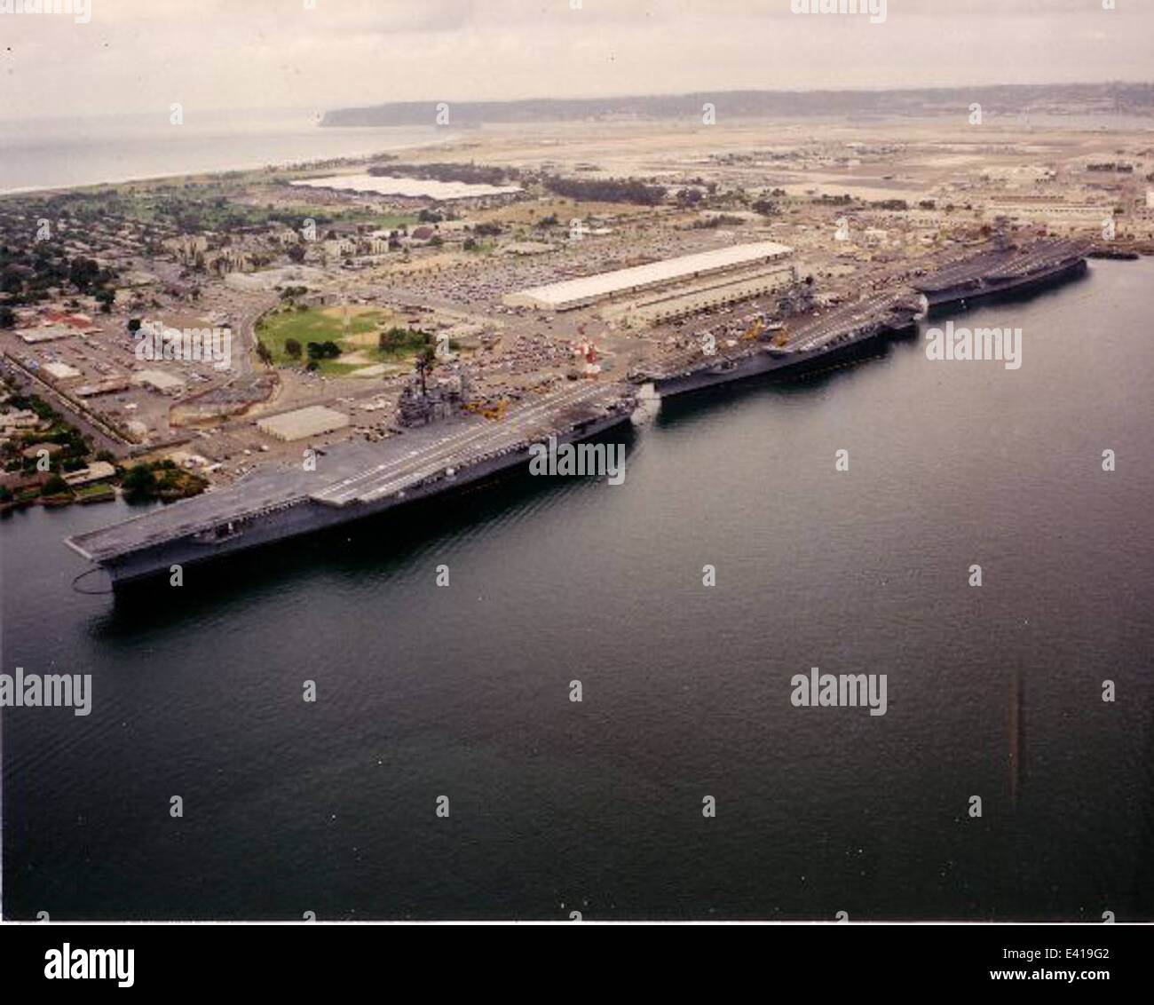 A photograph showing three aircraft carriers moored at Naval Air ...