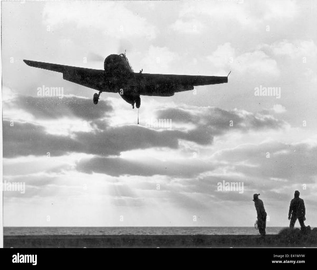 A TBF Avenger torpedo bomber silhouetted against a sunset, operating ...