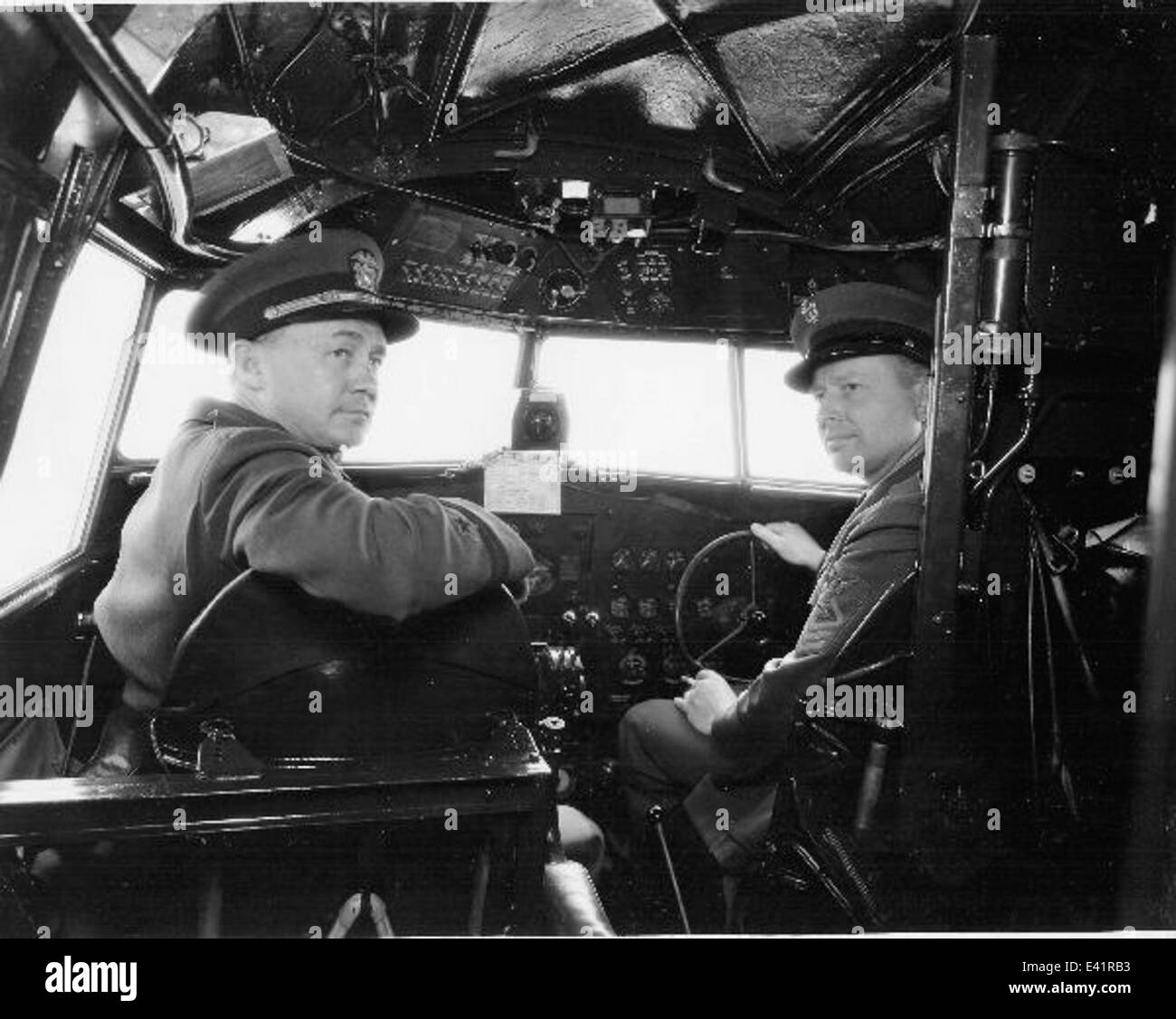 This photograph shows a pilot and a copilot in the cockpit of a Douglas ...