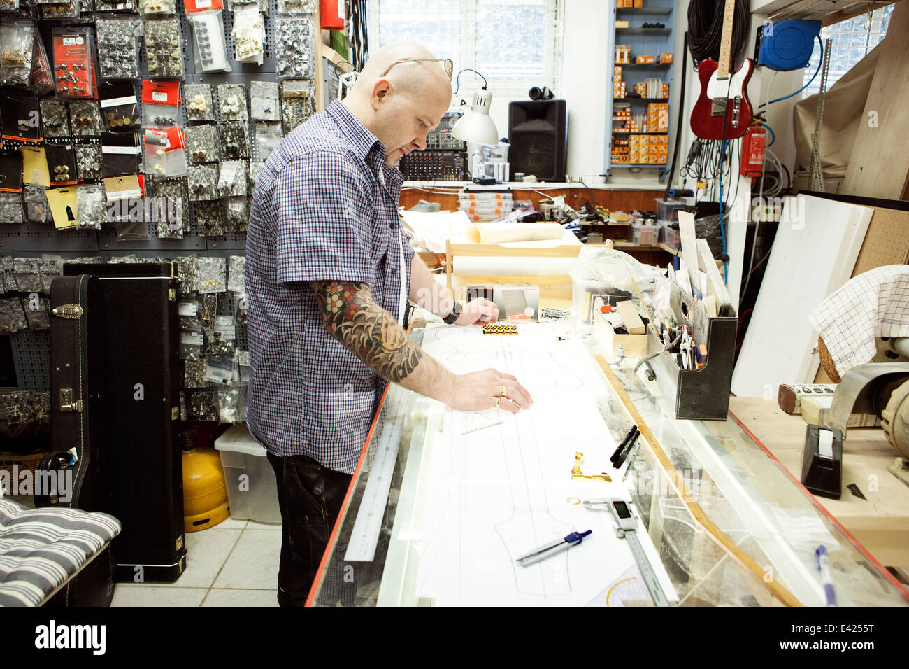 Guitar maker measuring up blueprint design on drawing table Stock Photo ...