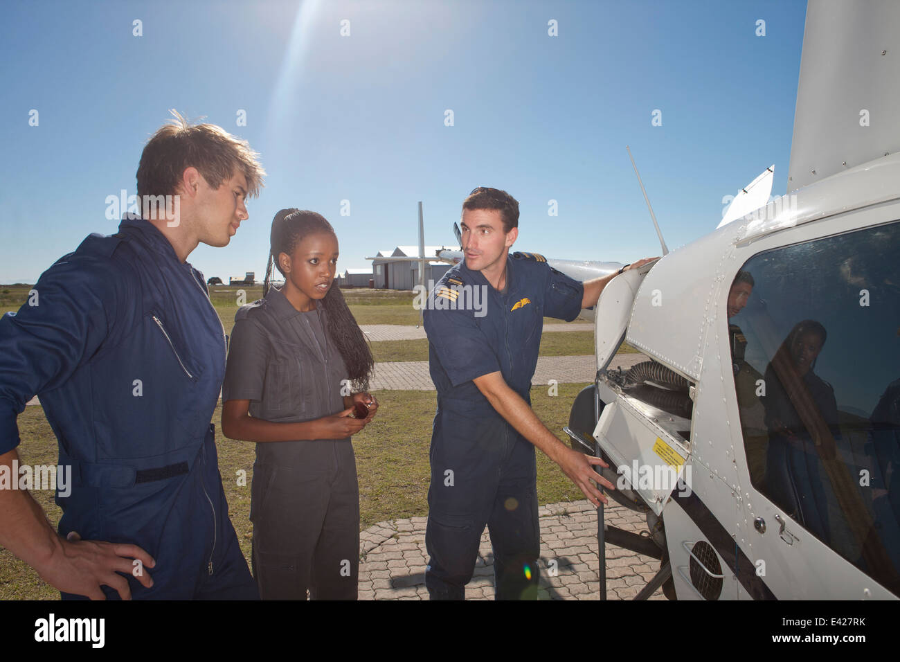 Flight instructor showing student pilots engine of helicopter Stock ...