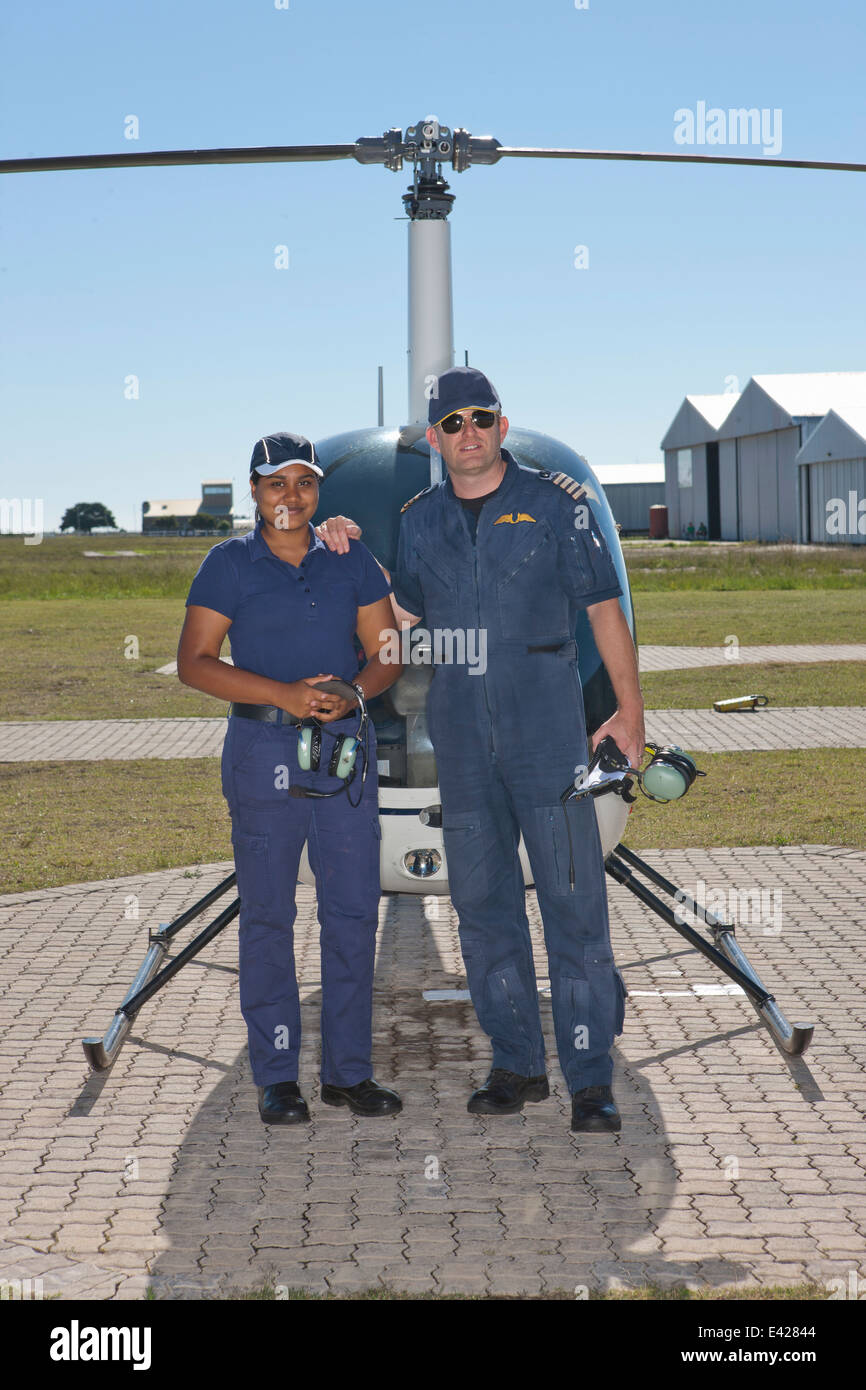 Pilots posing in front of helicopter Stock Photo - Alamy