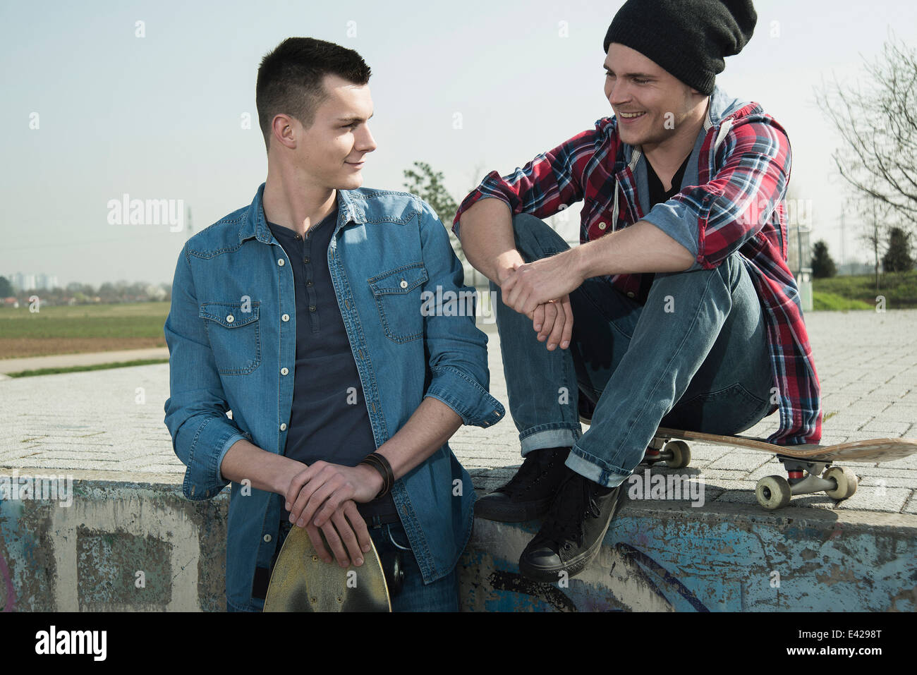 Young men sitting together at skatepark Stock Photo - Alamy
