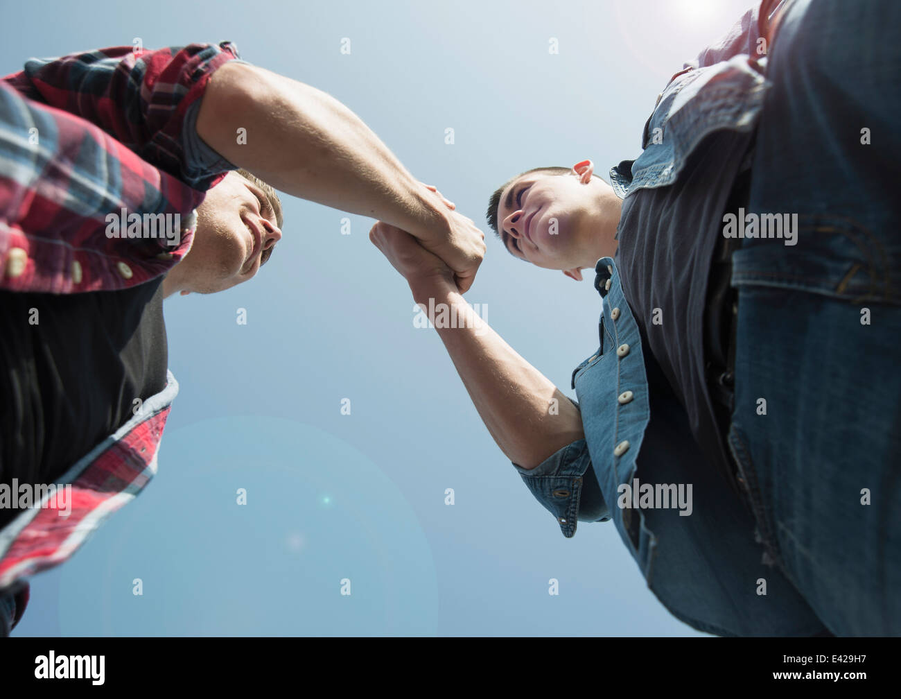 View from below of young men, shaking hands Stock Photo - Alamy
