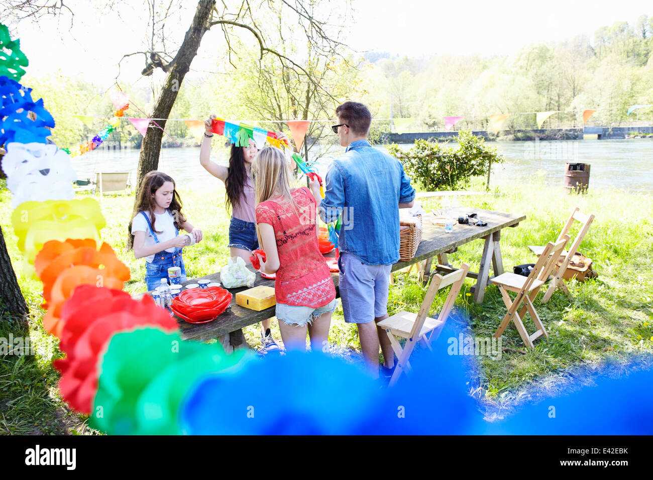 Group of friends setting up picnic Stock Photo - Alamy