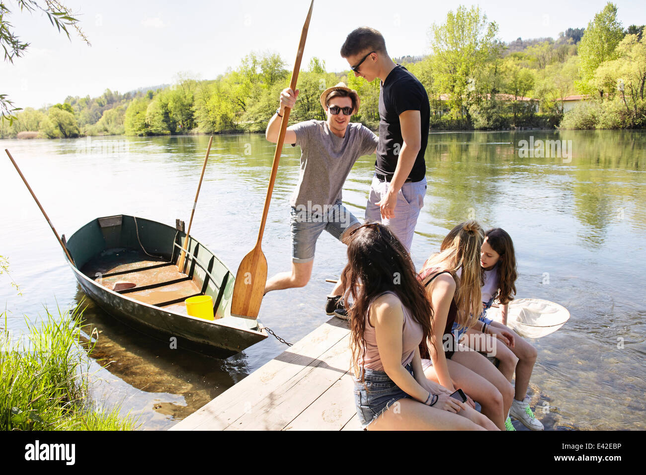 Group of friends with a row boat Stock Photo - Alamy