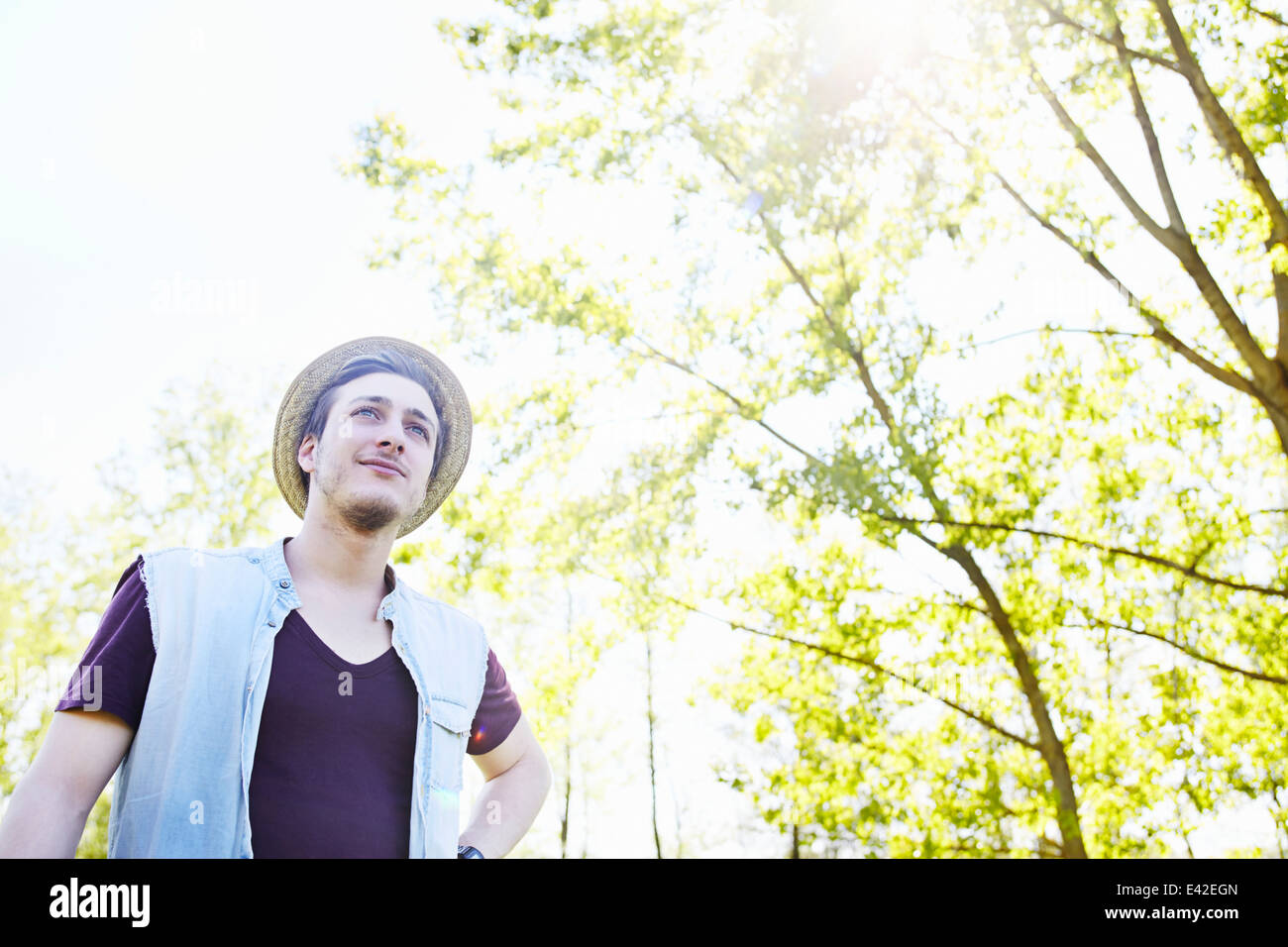 Young man wearing straw hat, low angle Stock Photo - Alamy