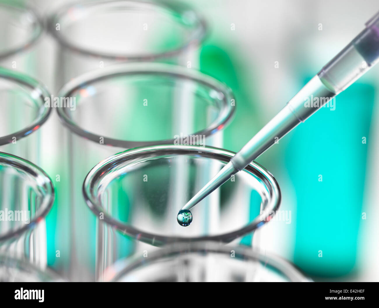 Pipette dripping liquid into test tube Stock Photo - Alamy