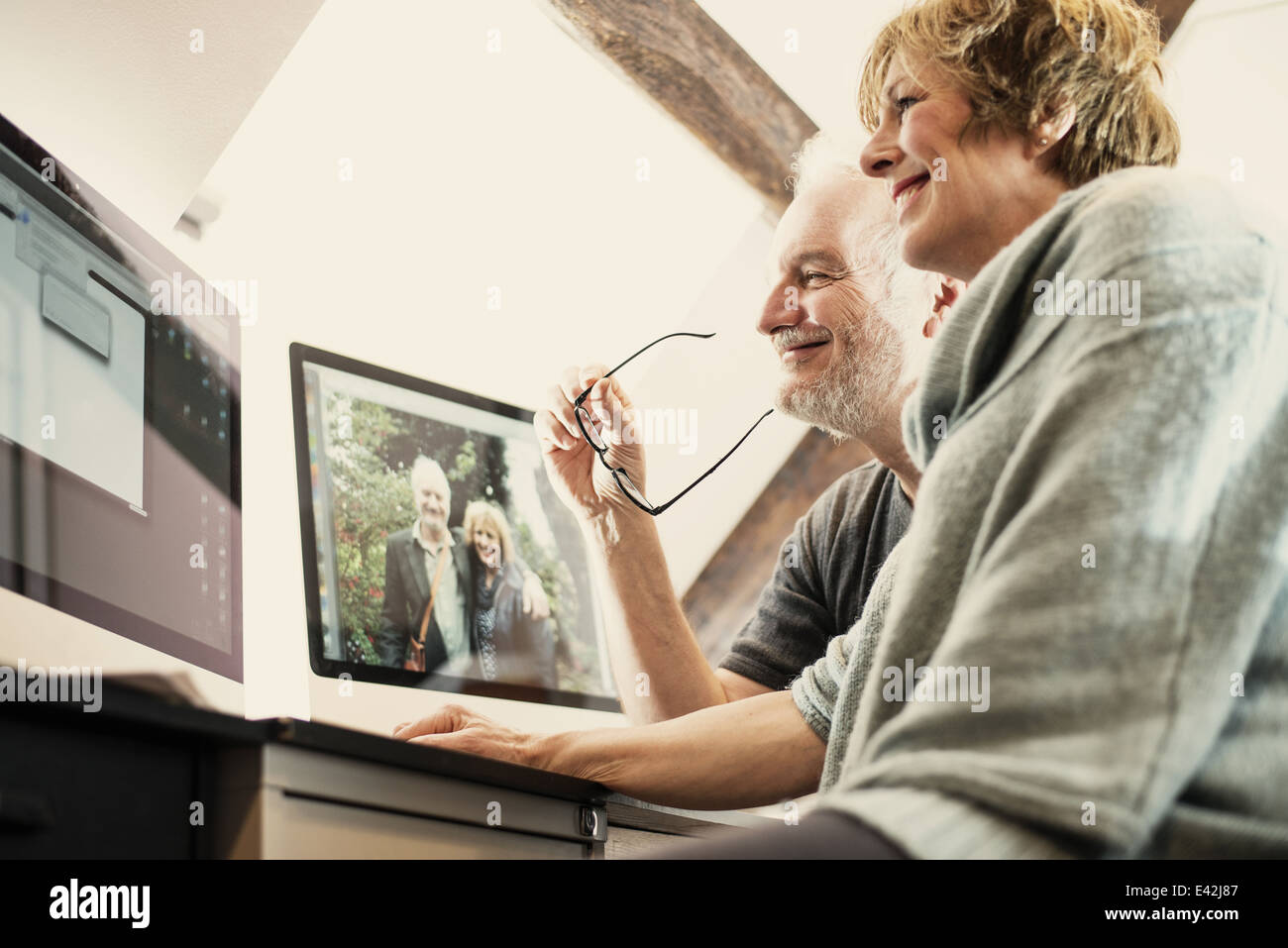 Couple using computer at home Stock Photo - Alamy