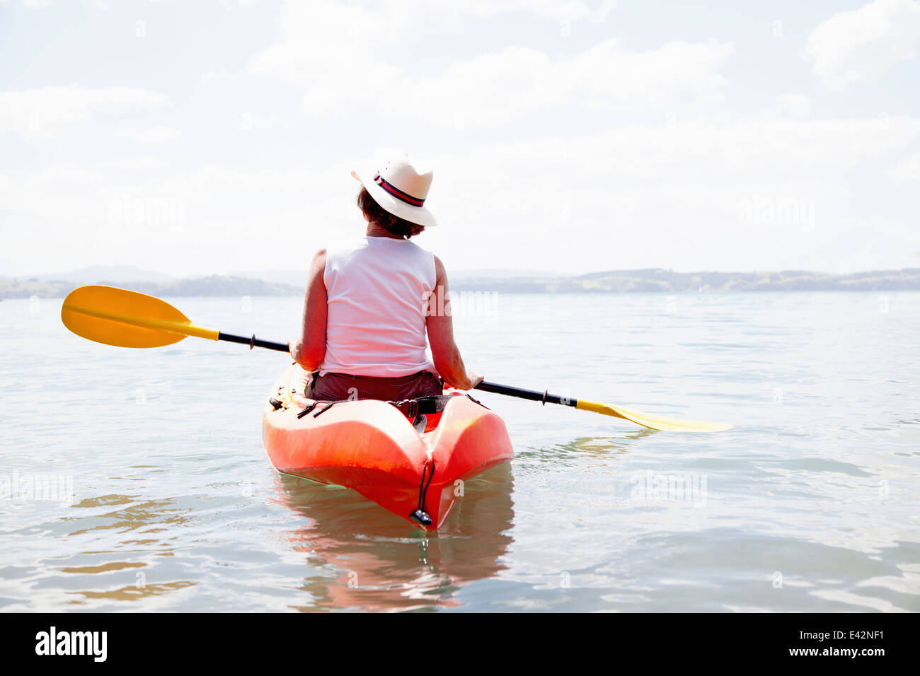 Rear view of senior woman sea kayaking Stock Photo - Alamy