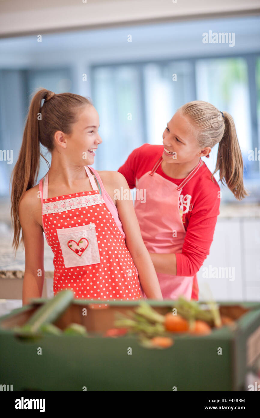 Two teenage girls preparing vegetables in kitchen Stock Photo - Alamy