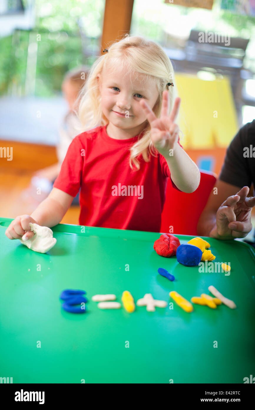 Portrait of girl counting with fingers at nursery school Stock Photo ...
