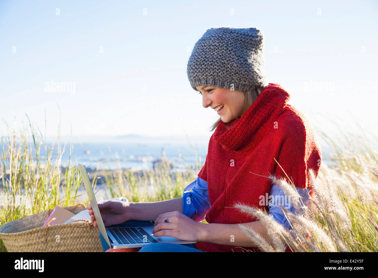 Young woman using laptop whilst sitting on hilltop Stock Photo - Alamy