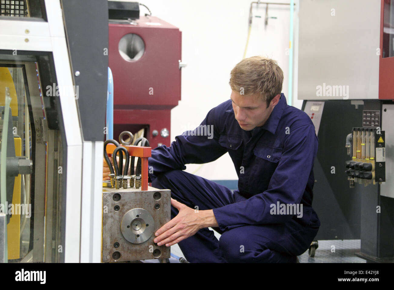 Male engineer maintaining manufacturing machine in factory Stock Photo ...