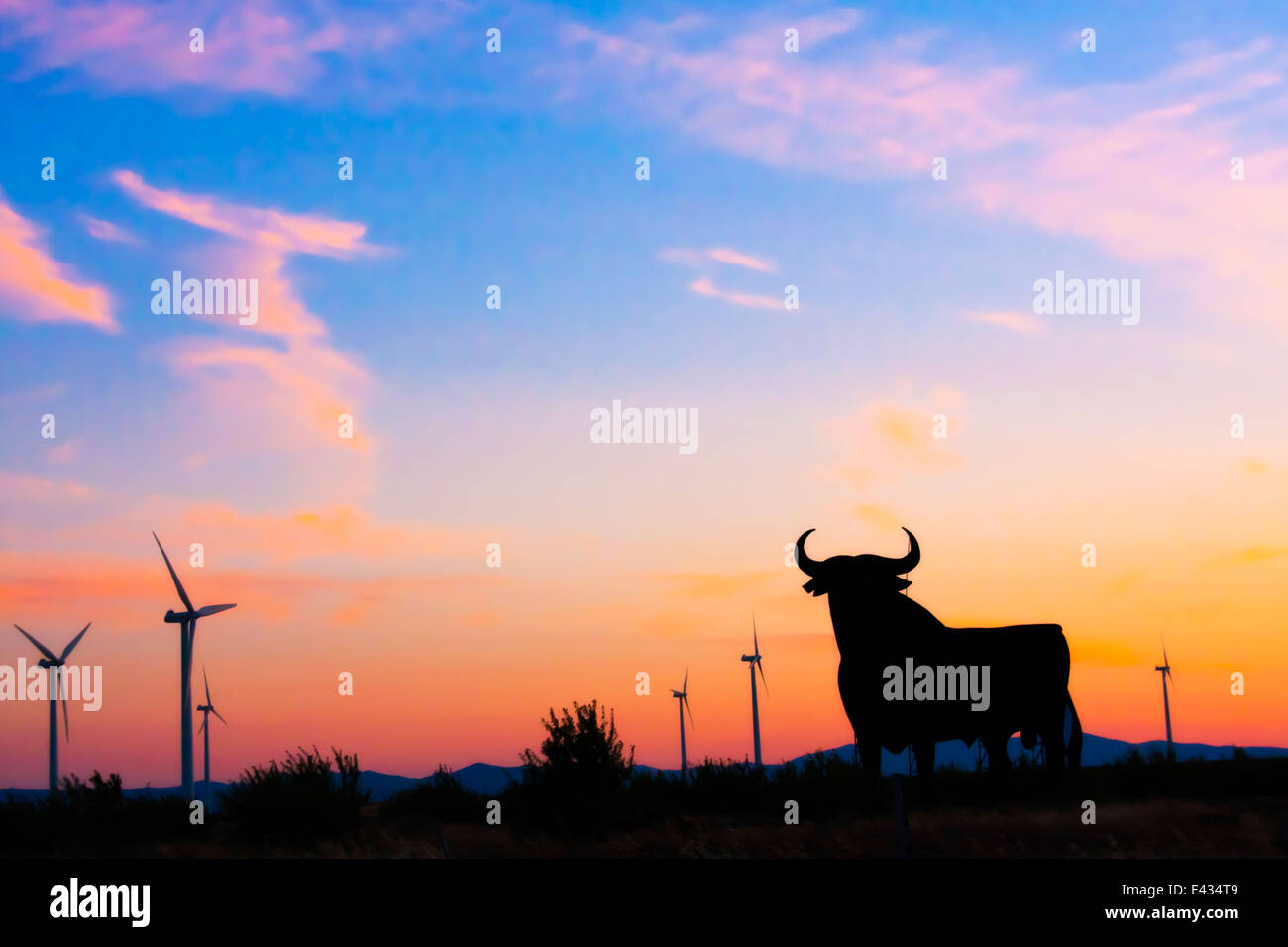 Spanish bull roadsign surrounded by wind turbines in sunset Stock Photo ...