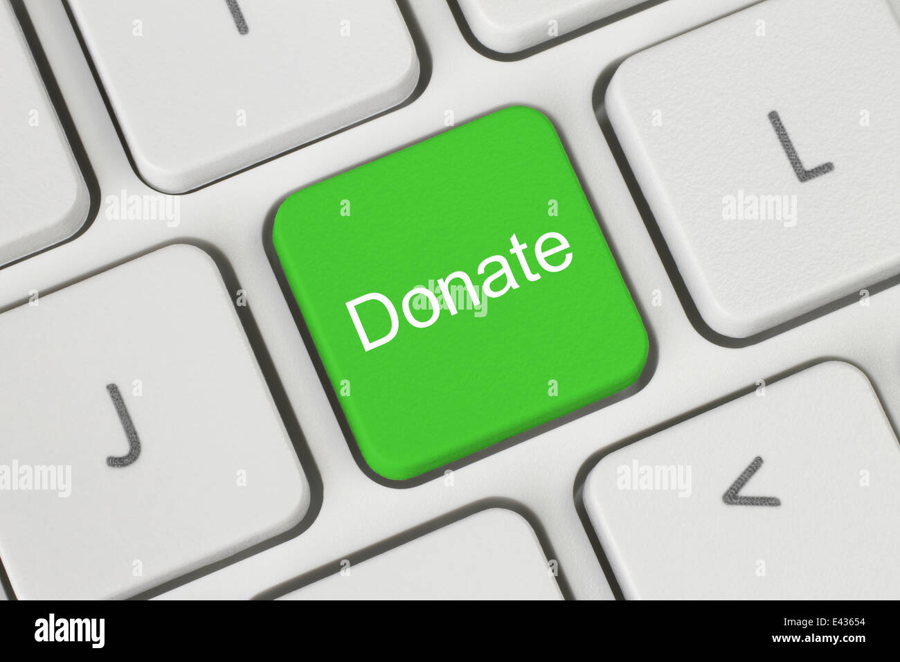 Green donate button on the keyboard close-up Stock Photo - Alamy