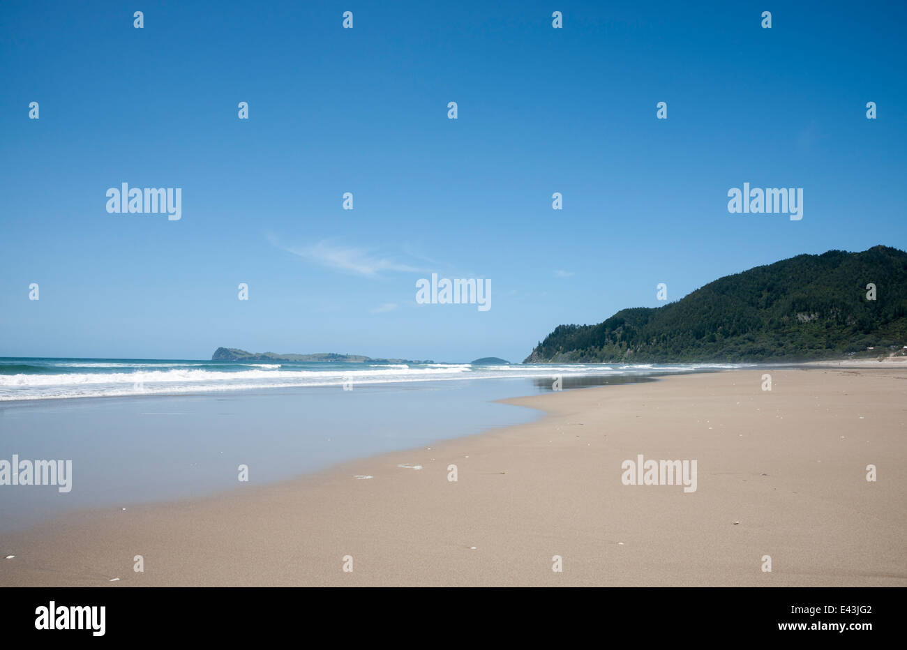 Idyllic beach scene, wide sandy expanse, sea and blue sky Stock Photo ...