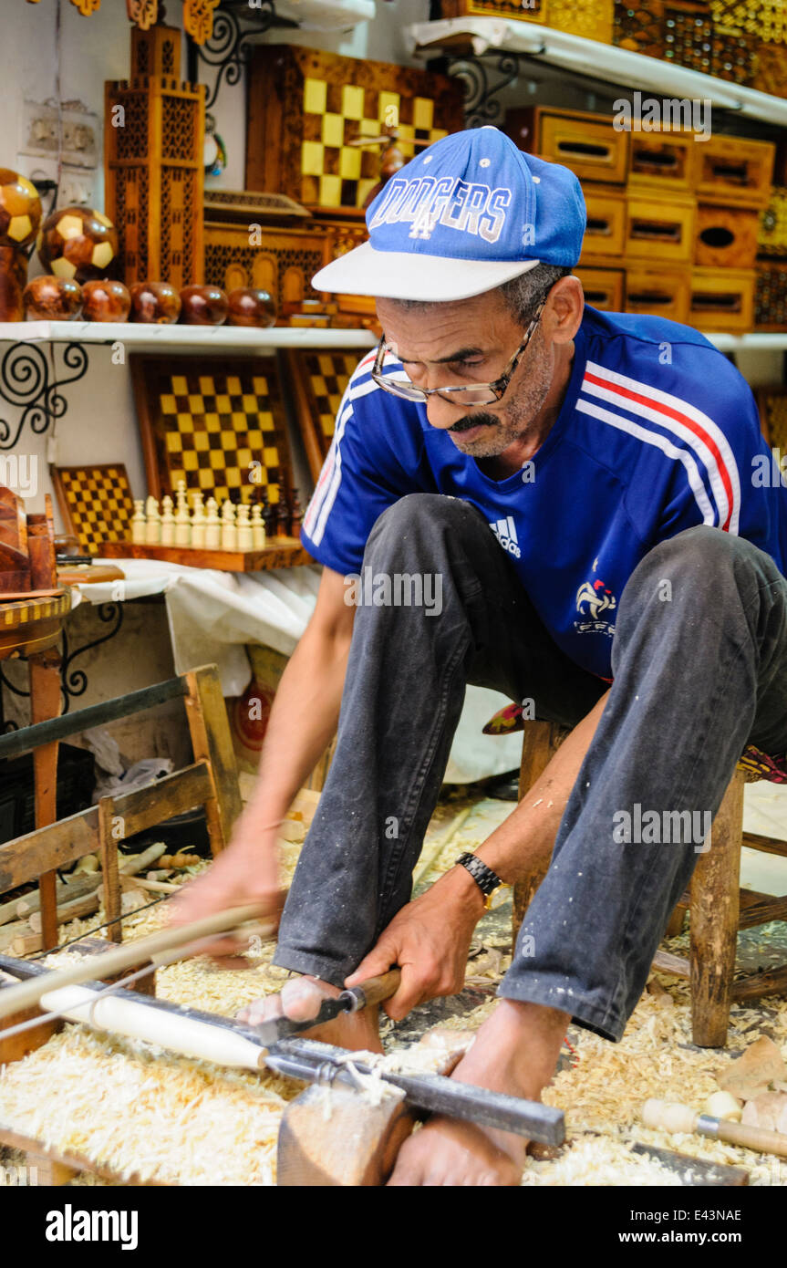 A Berber uses a traditional woodturning lathe while holding the ...