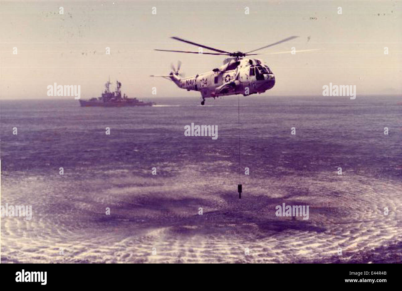This photograph shows an SH-3A Sea King helicopter performing a dipping ...